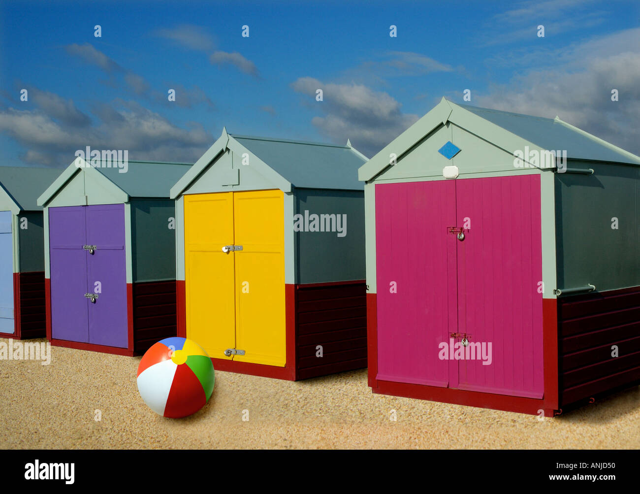row of beach huts on sandy beach with beach ball Stock Photo - Alamy