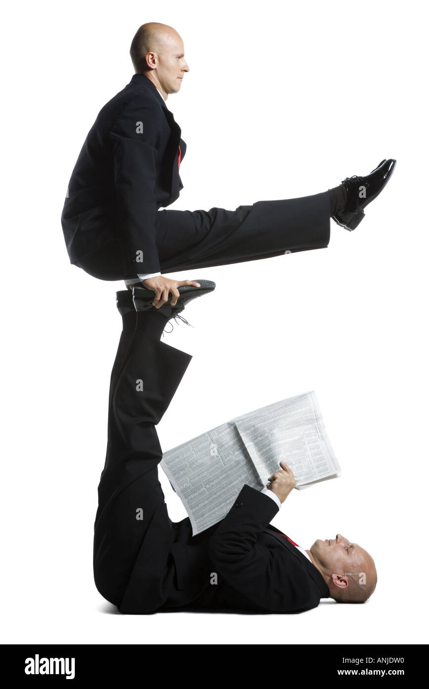 Two male acrobats in business suits performing Stock Photo - Alamy