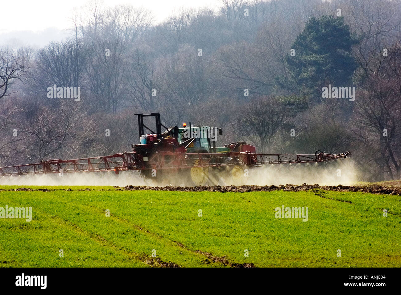 Spraying field from tractor Stock Photo - Alamy