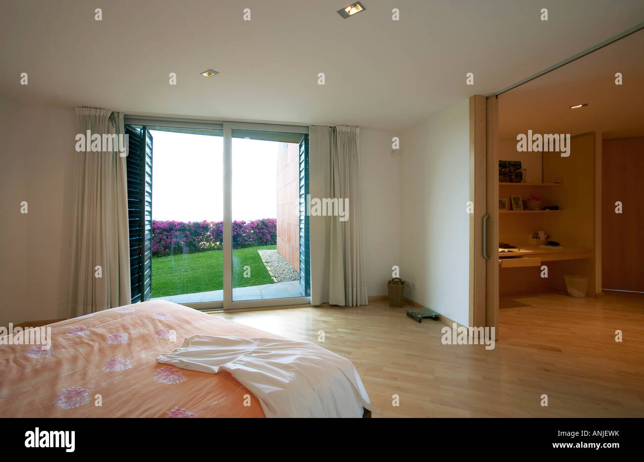 White dress on bed in bedroom with wood flooring sliding door and ...