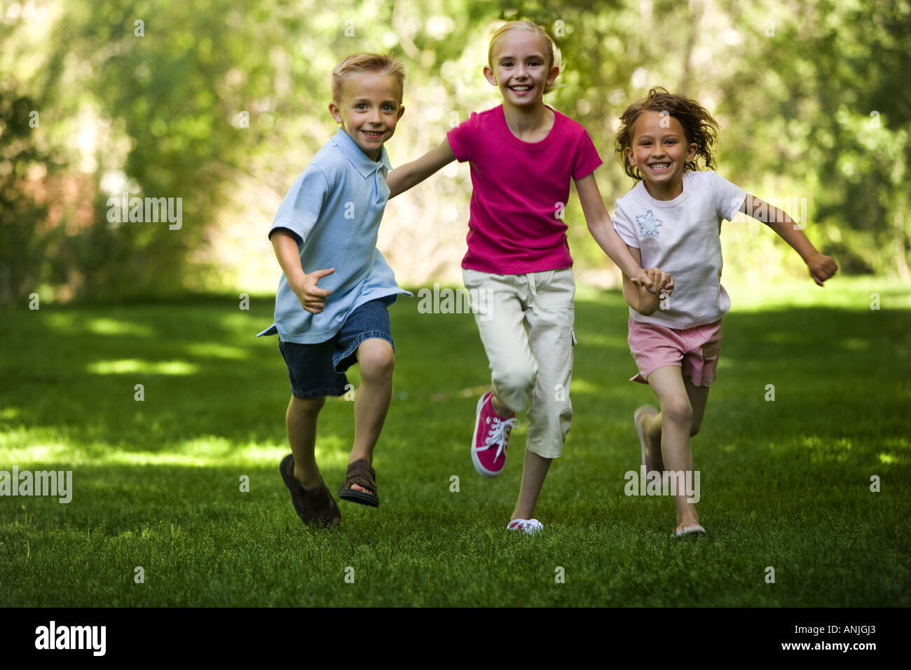 Portrait of three children running Stock Photo - Alamy