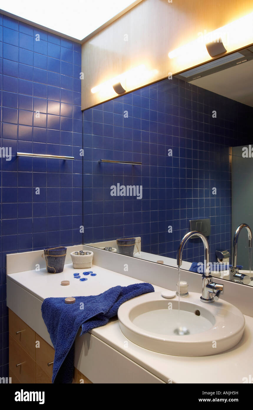 Bathroom with chrome faucet and blue tile wall Stock Photo - Alamy