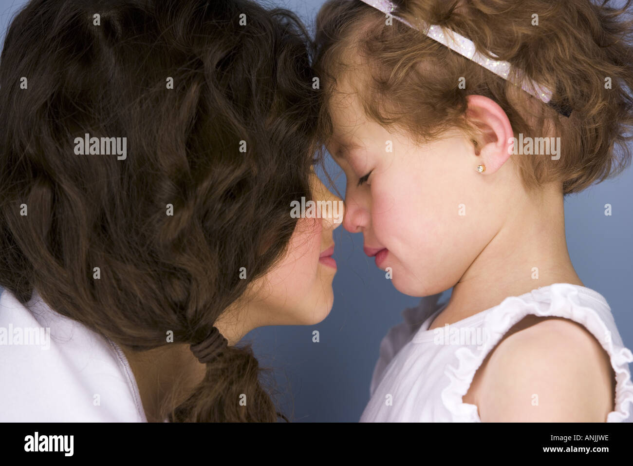Side profile of two sisters rubbing their noses Stock Photo - Alamy