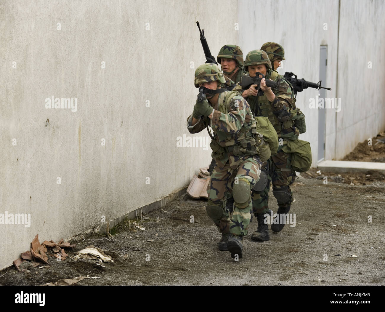 Four soldiers walking in a row aiming their rifles Stock Photo - Alamy