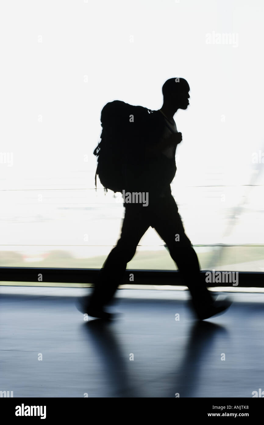 Silhouette of a backpacker walking in an airport Stock Photo - Alamy