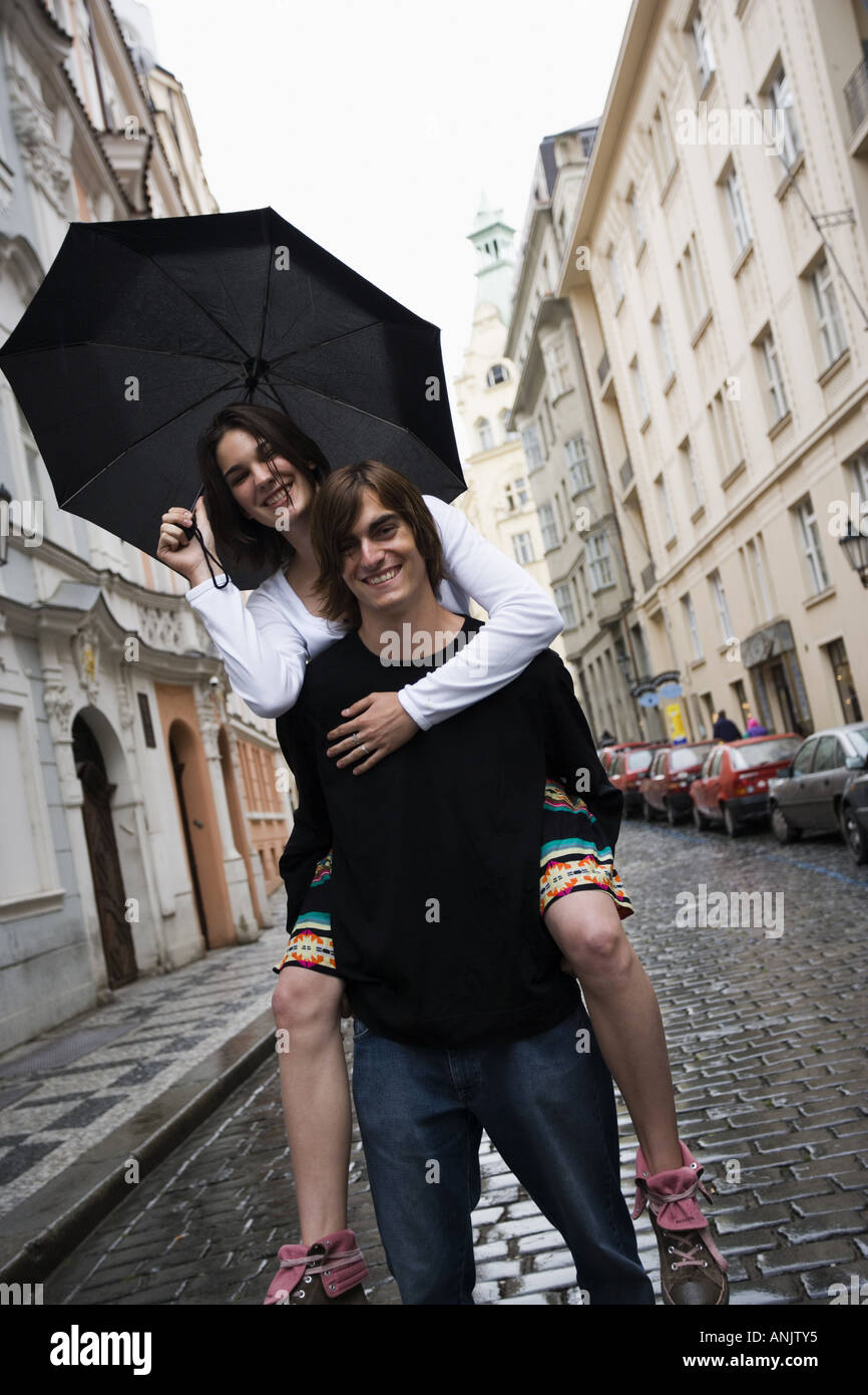 Young man giving a piggyback ride to a teenage girl Stock Photo - Alamy