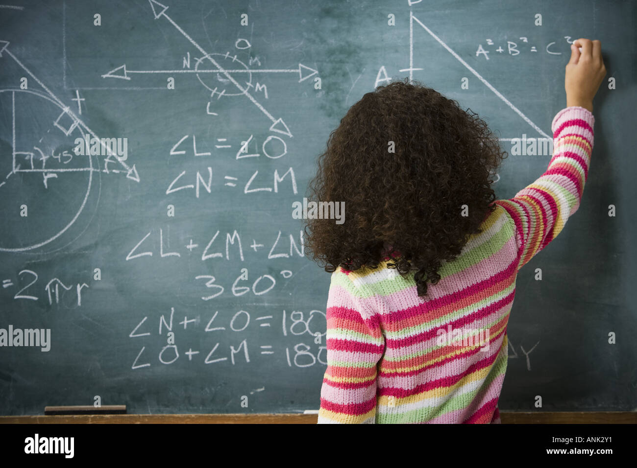 Rear view of a girl writing on a blackboard Stock Photo - Alamy