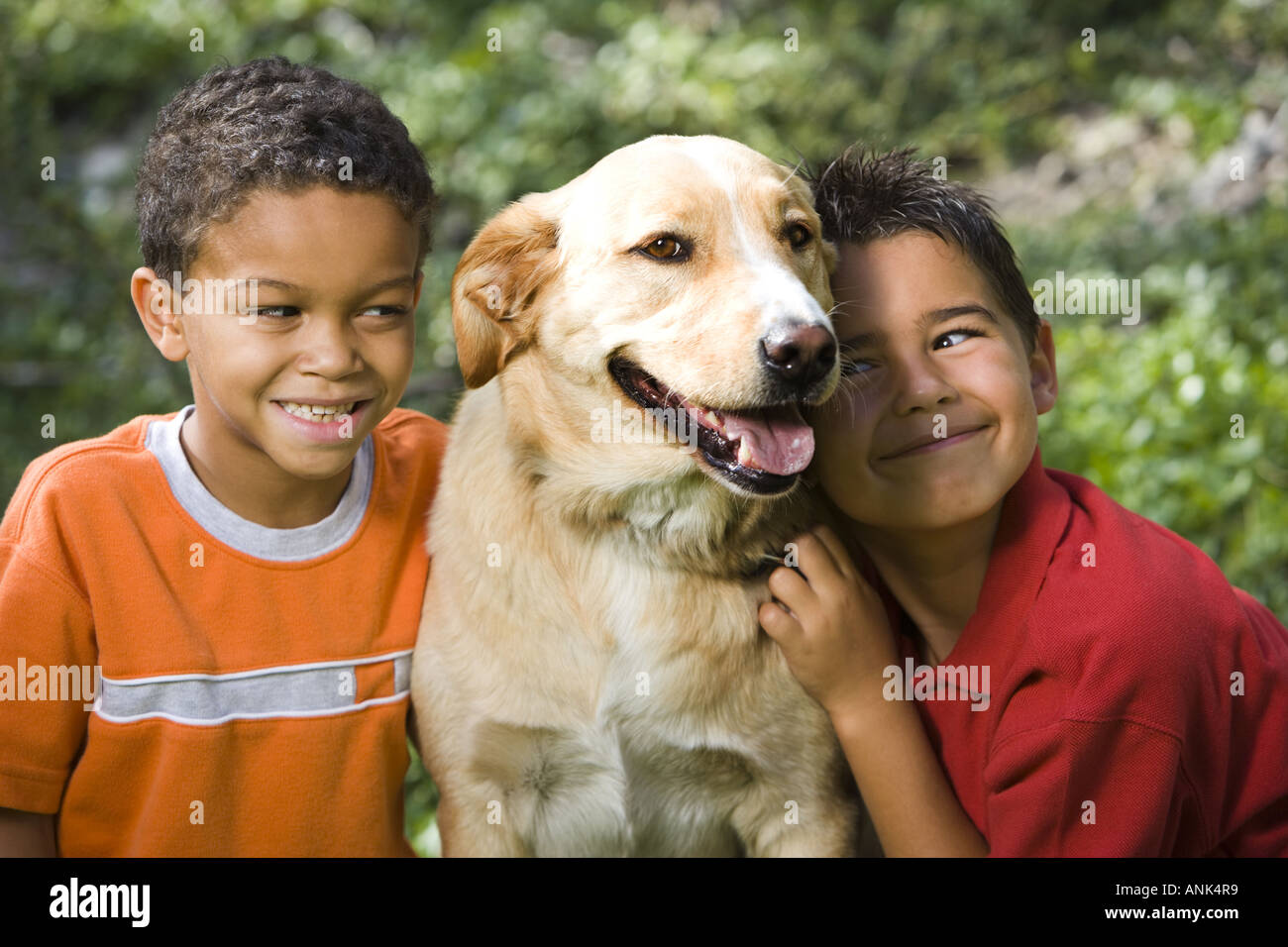 Two boys sitting with a dog Stock Photo - Alamy