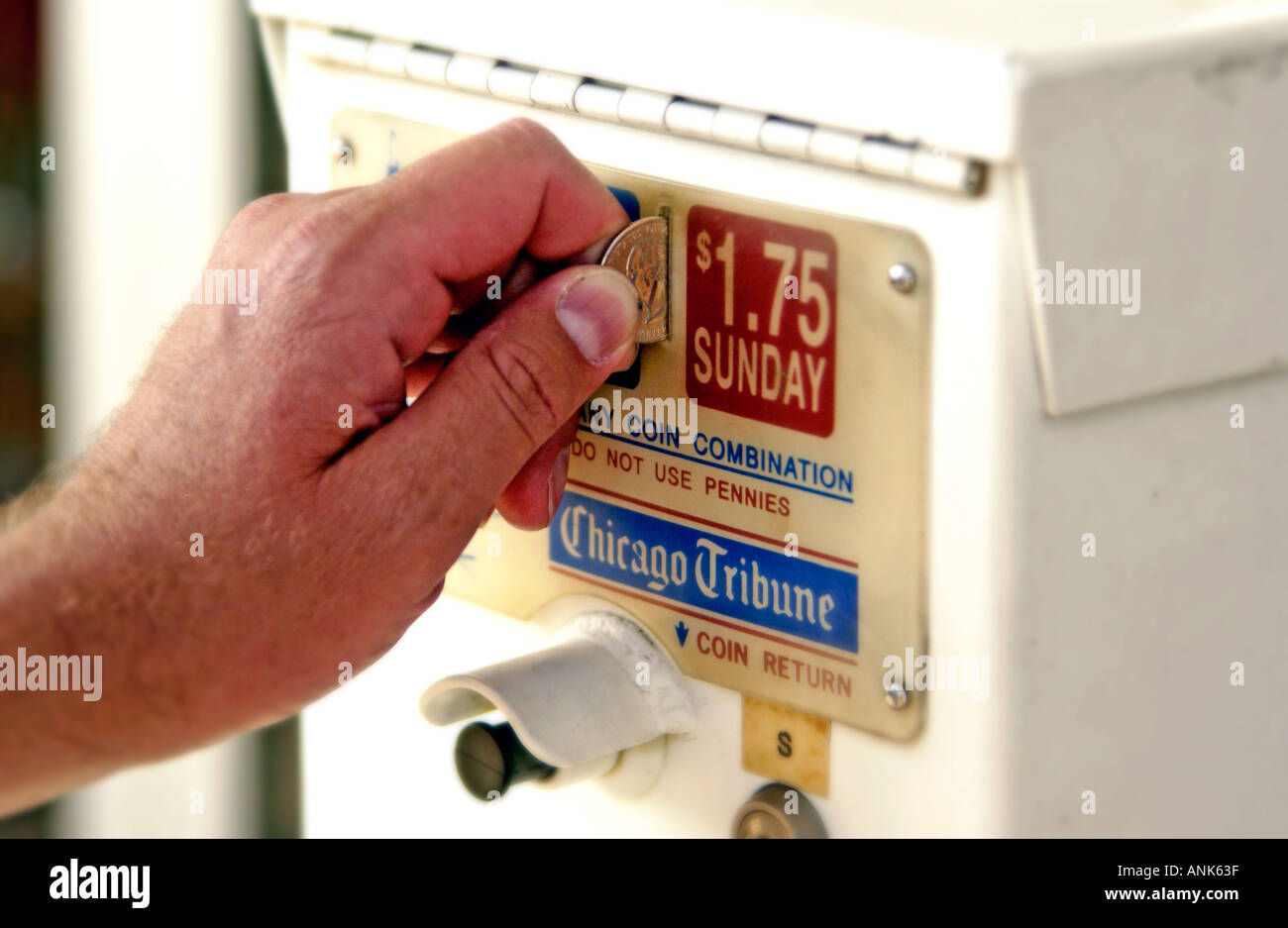 Person purchasing newspaper from coin operated stand Stock Photo - Alamy