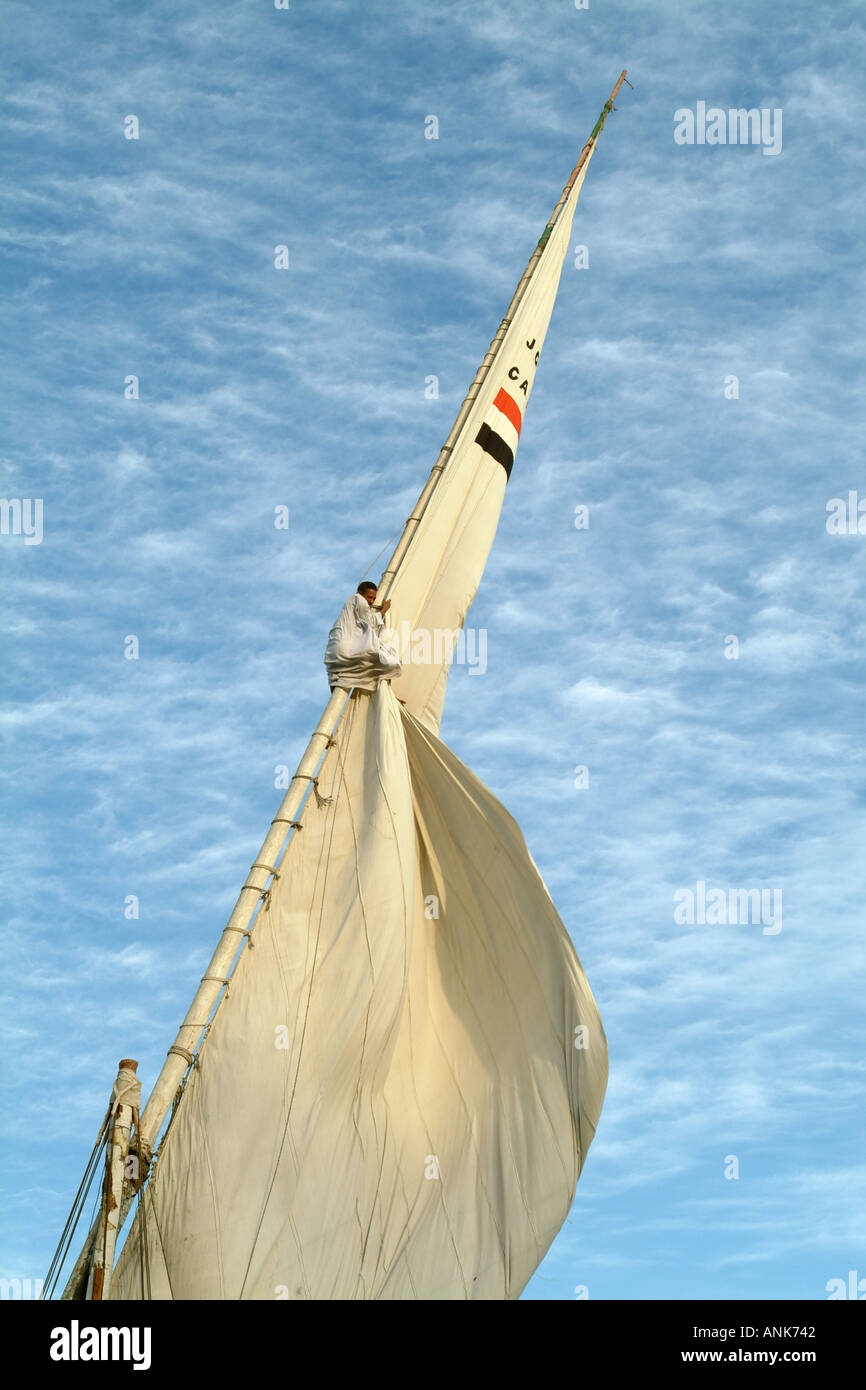 A sailor on the mast of his felucca tieiing the sail up in Egypt Stock ...