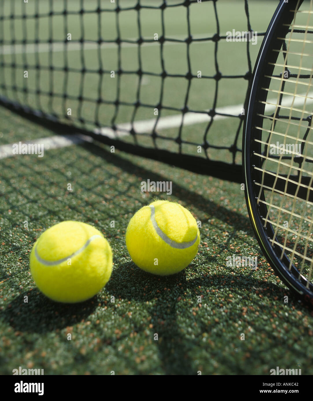 detail of tennis balls and racket resting on tennis court net Stock ...