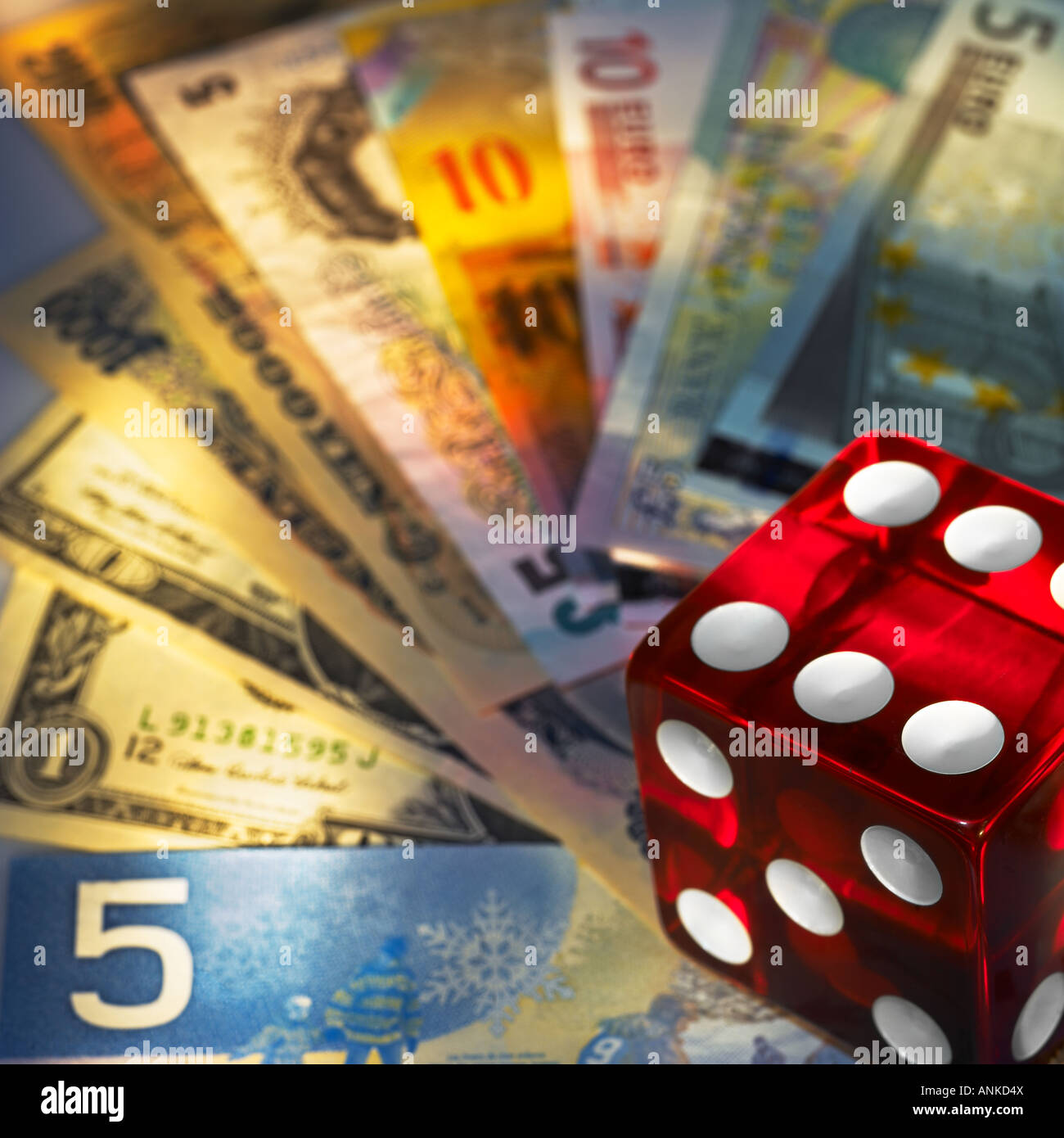 Red die over the different banknotes Stock Photo - Alamy