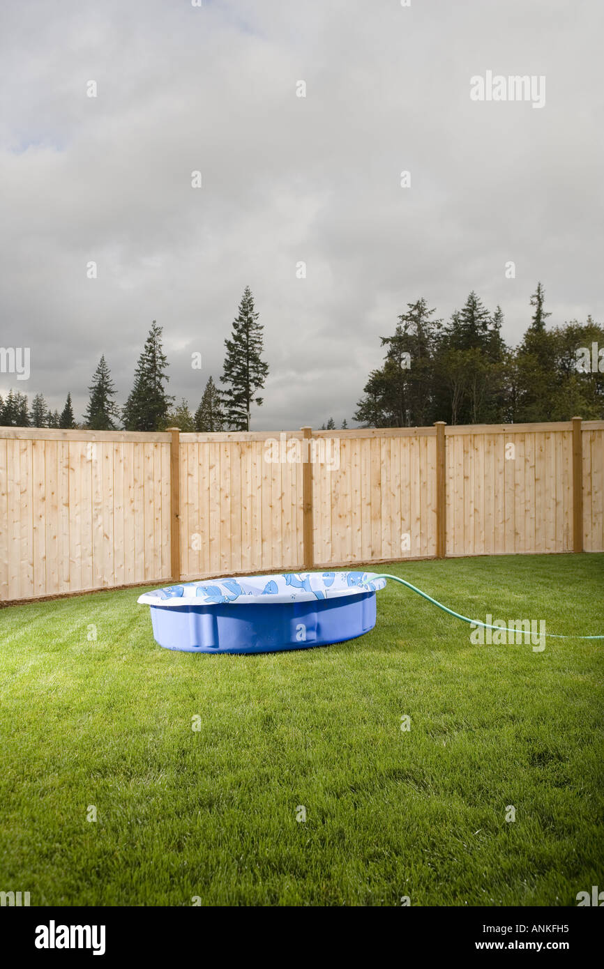 Wading pool with hose on a lawn Stock Photo - Alamy