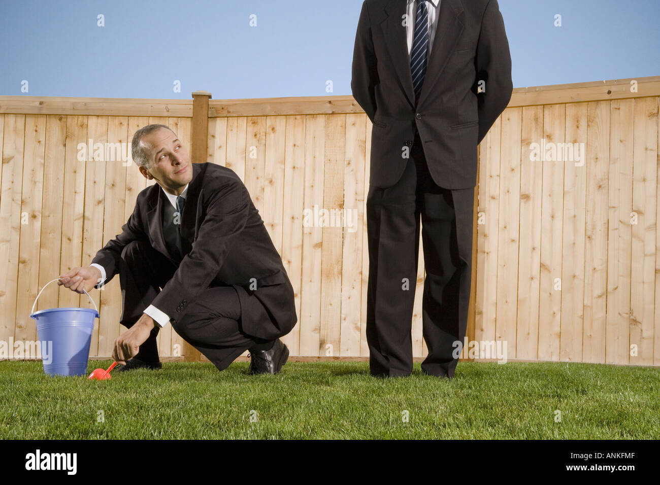 Low angle view of a businessman crouching with another businessman ...