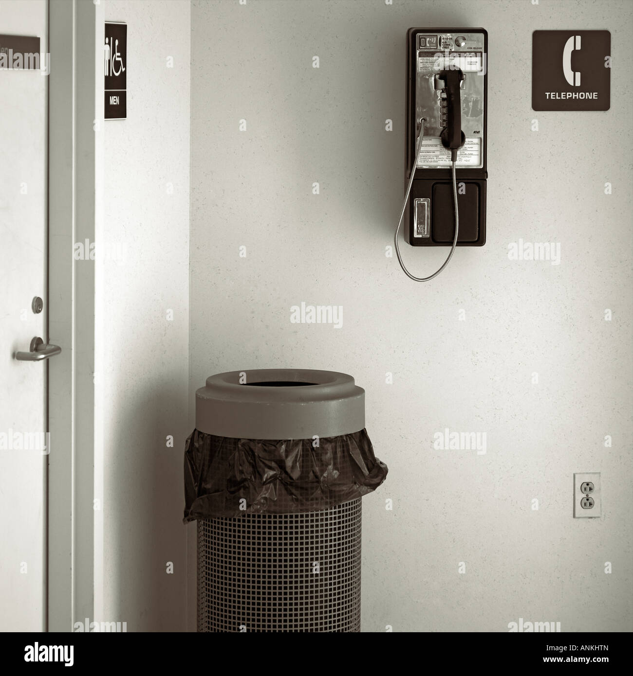 Room with public phone and trash can Stock Photo - Alamy