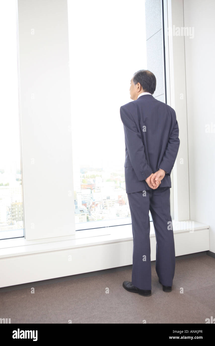 Chief executive officer looking at outside from room Stock Photo - Alamy