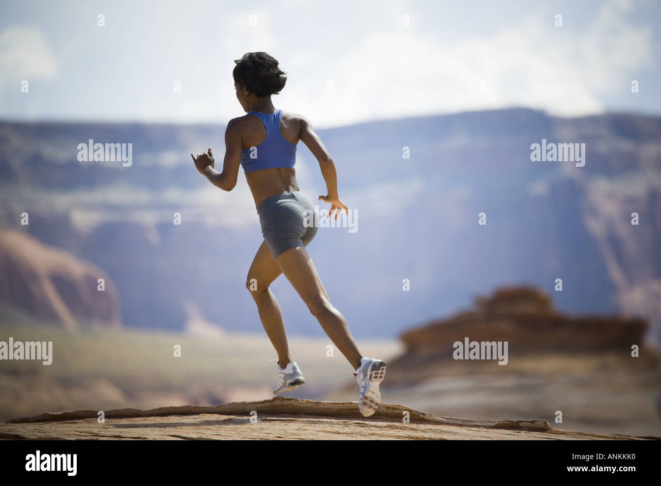 Rear view of a young woman jogging Stock Photo - Alamy