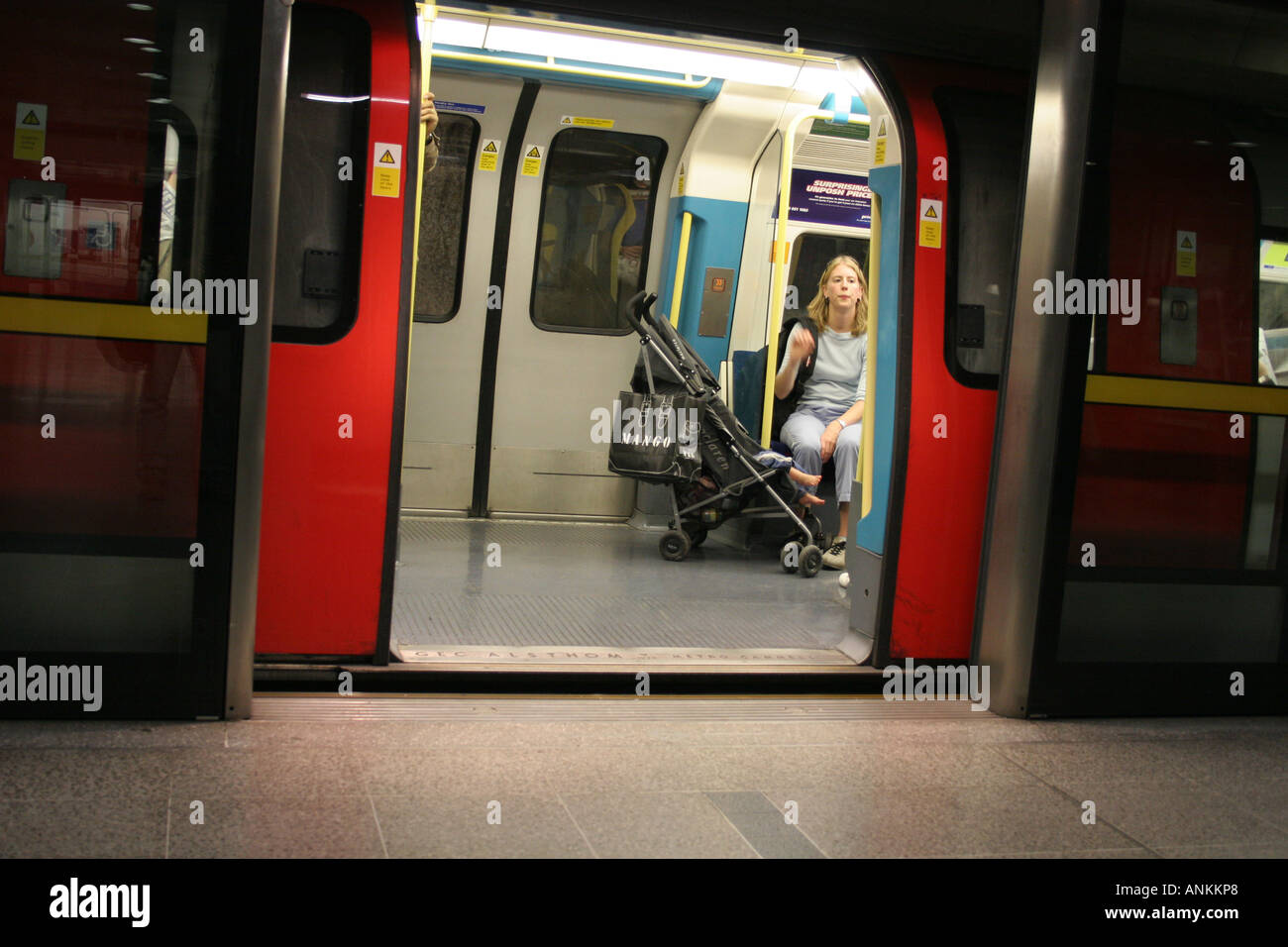 Woman seating inside tube with baby pram Stock Photo - Alamy
