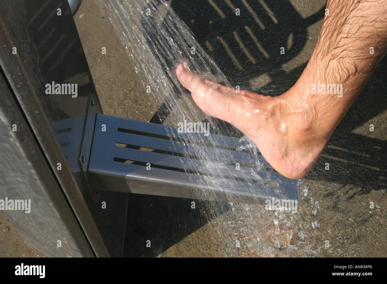 Man rinsing sand from his feet Stock Photo - Alamy