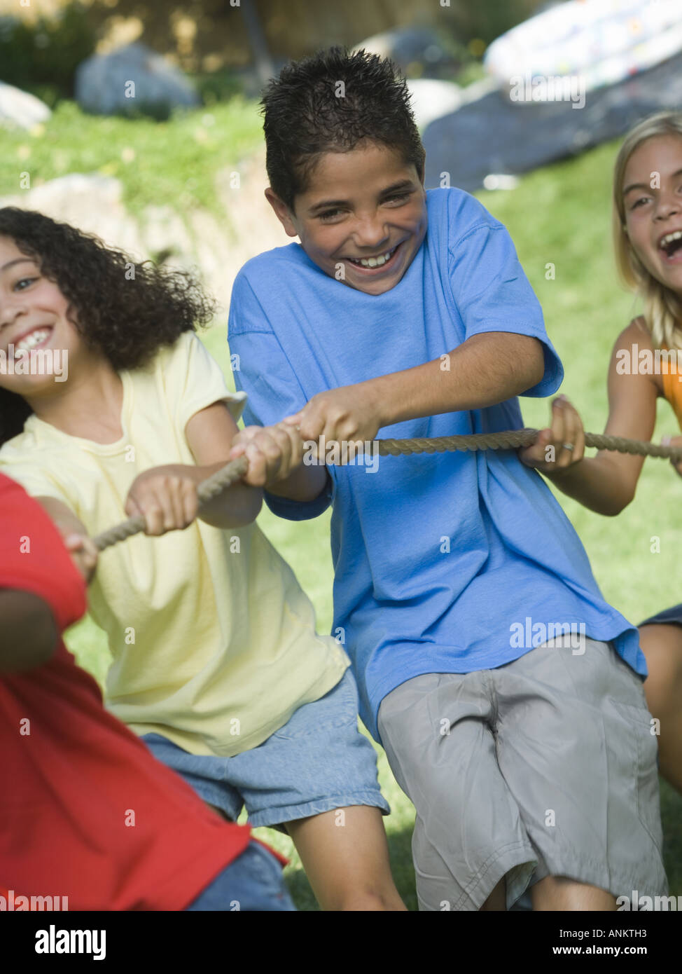 Children pulling the rope and smiling Stock Photo - Alamy