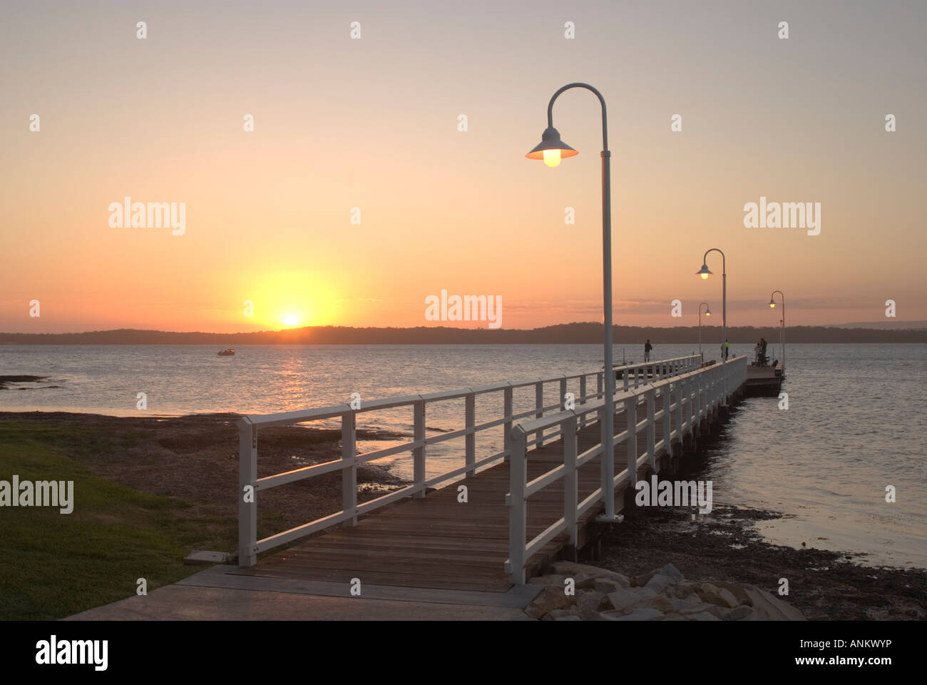 A small pier looking out into Lake Macquarie at sunset Stock Photo - Alamy