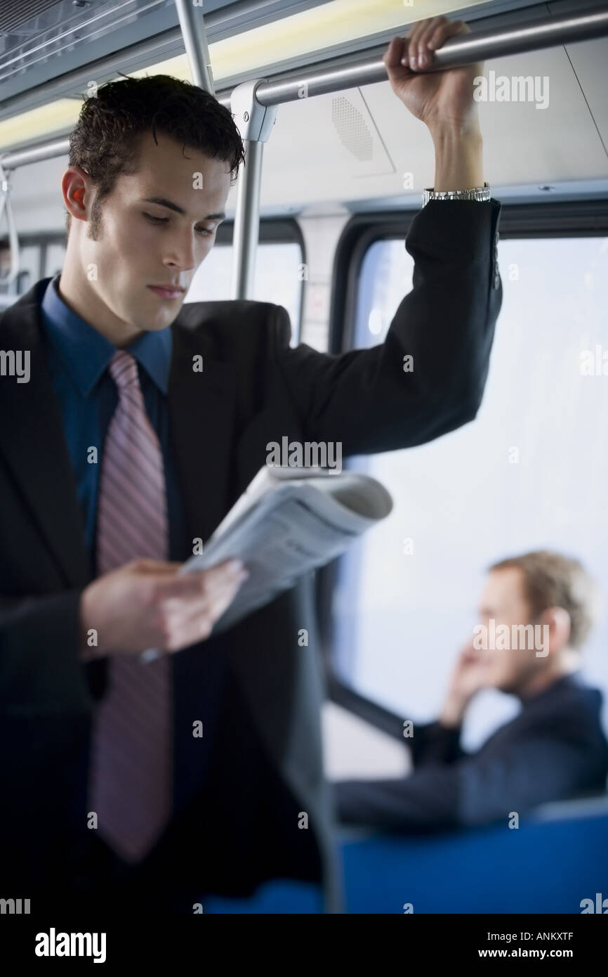 Man on subway train newspaper hi-res stock photography and images - Alamy
