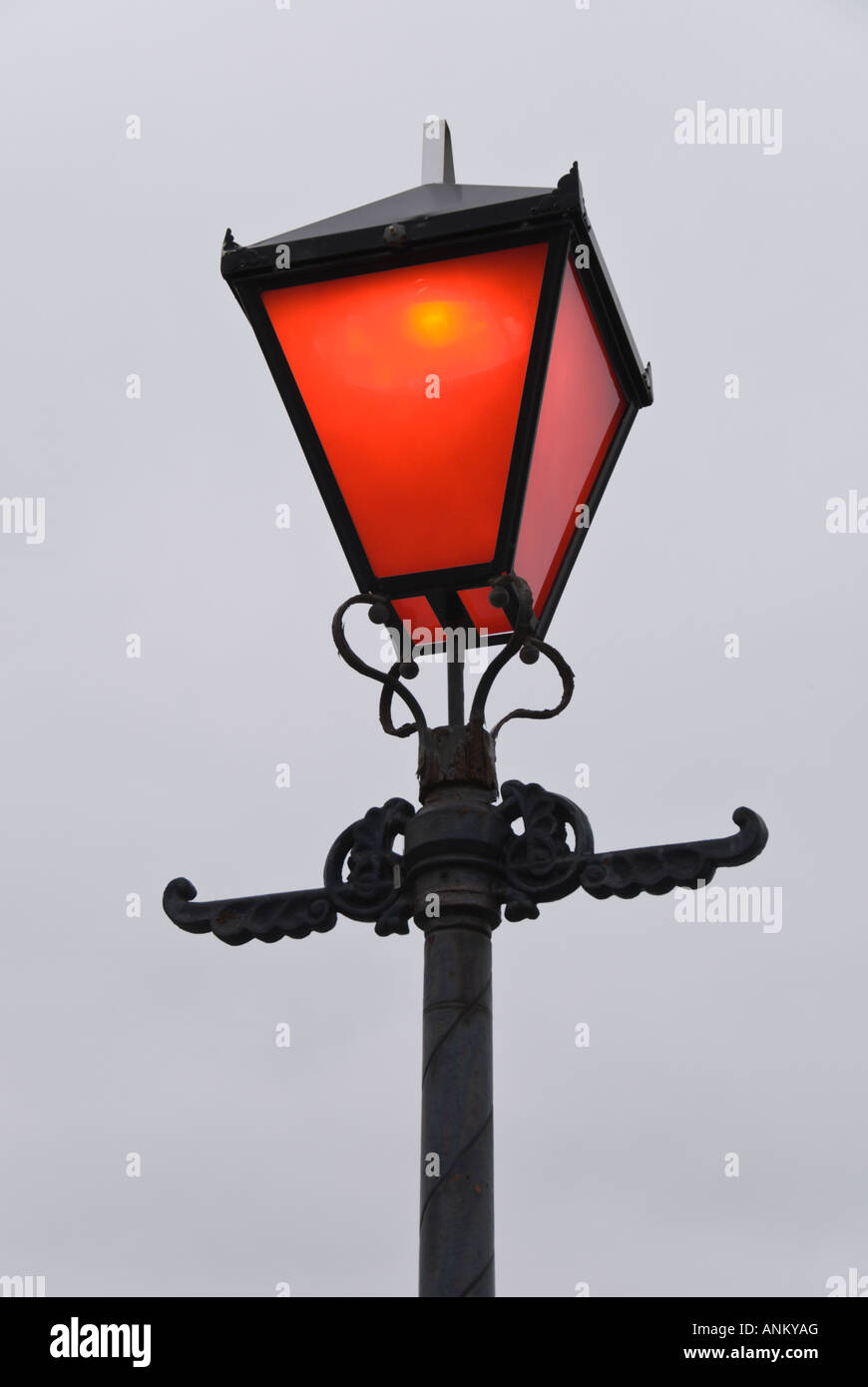 A red lampost or streetlight on a grey sky background Stock Photo - Alamy