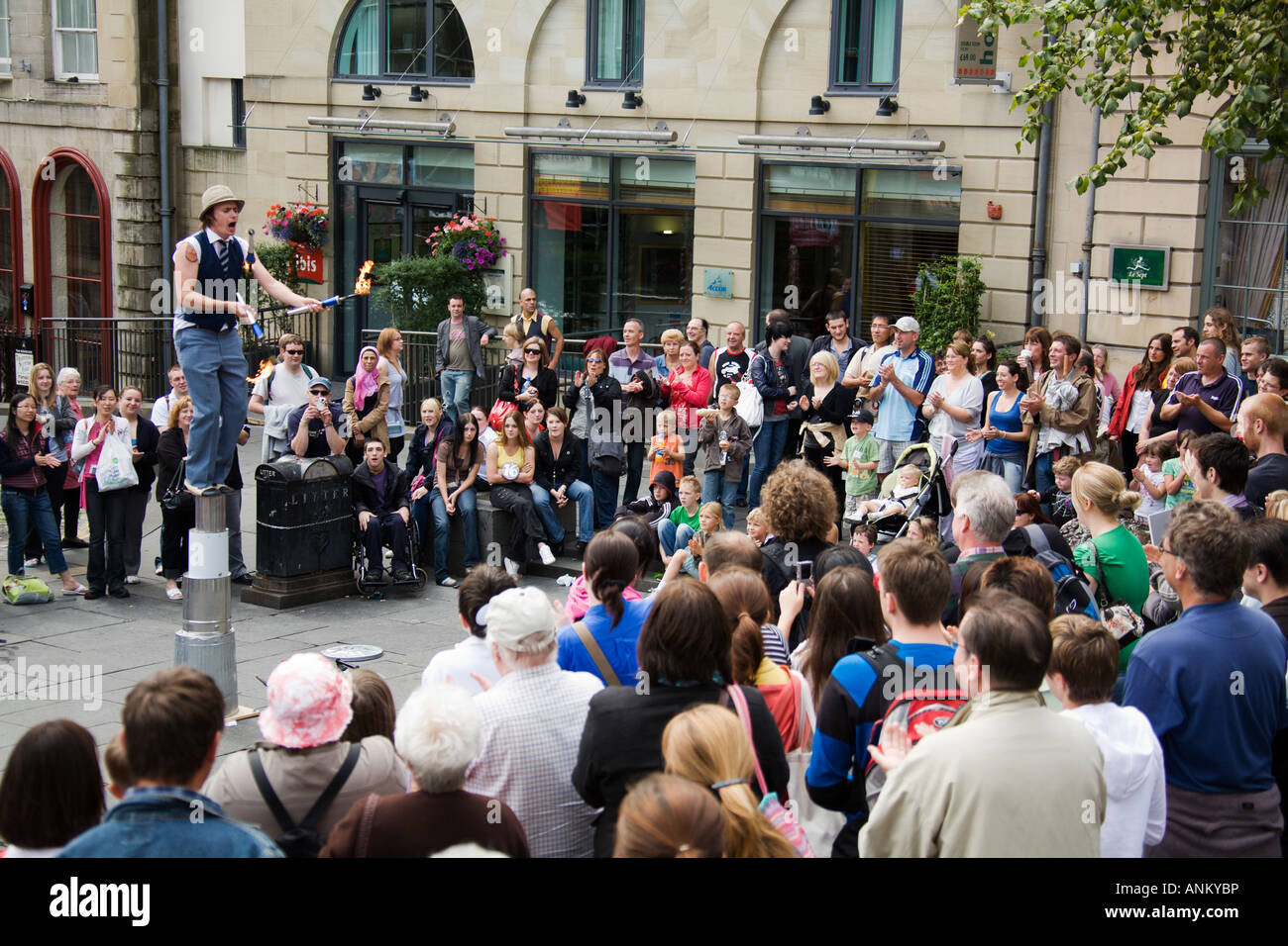 Performer juggles fire balancing on buckets in front of crowd at ...
