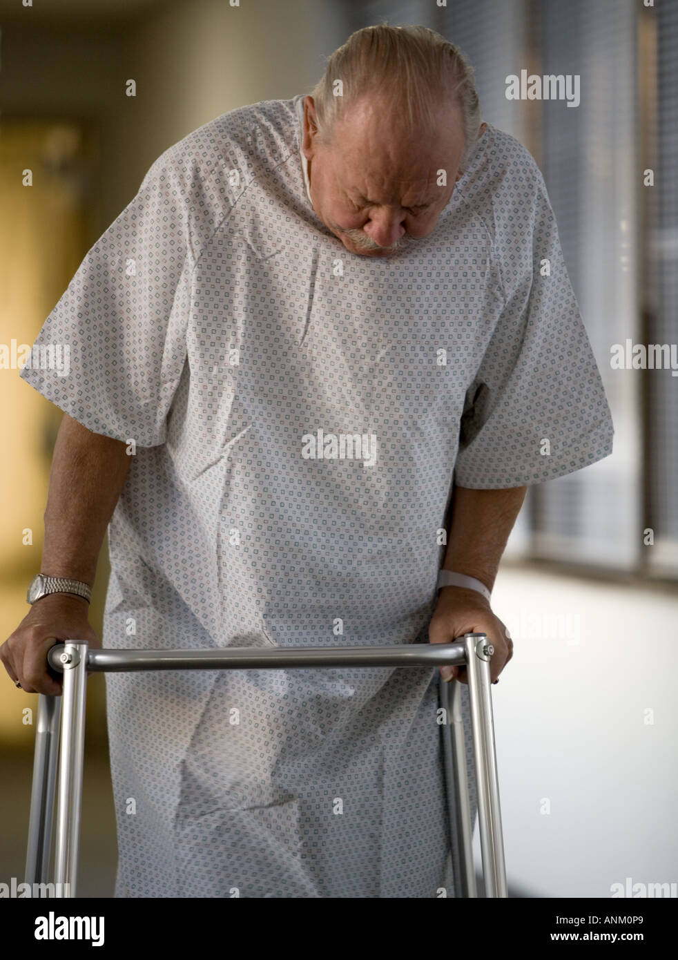 Male patient walking with a walker in a corridor Stock Photo - Alamy
