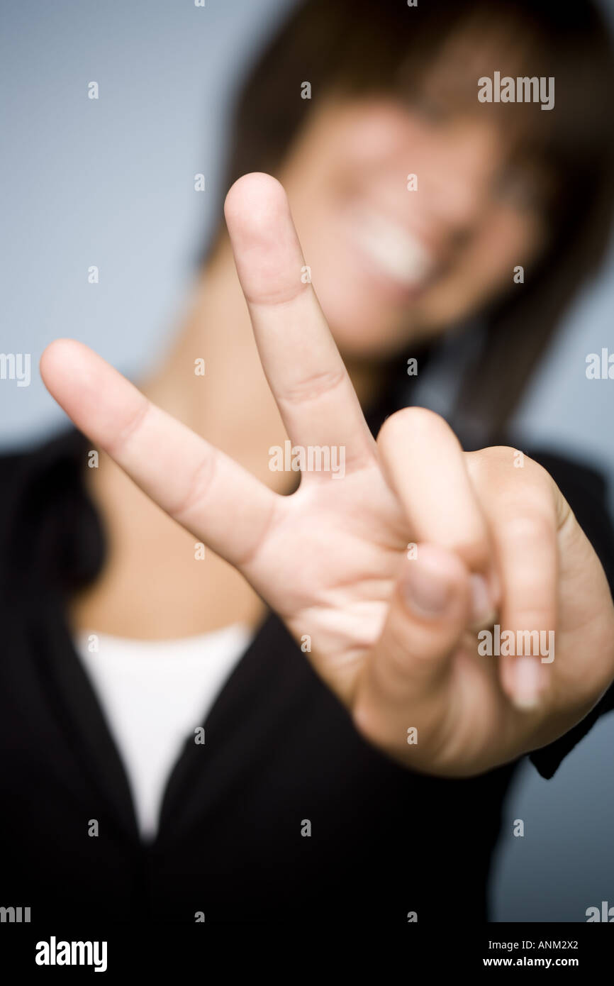 Teenage girl making a peace sign Stock Photo - Alamy