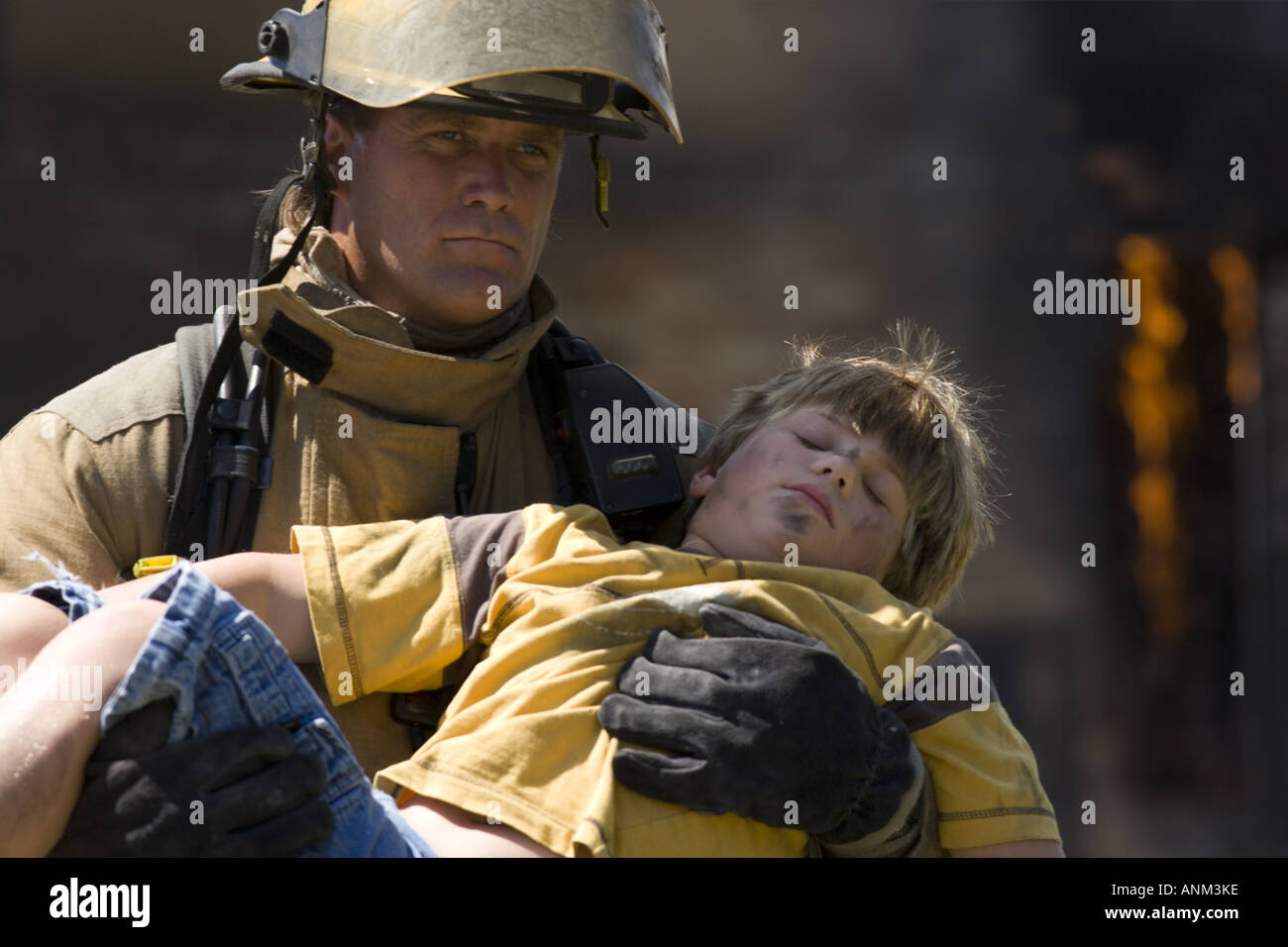Firefighter carrying a wounded boy Stock Photo - Alamy