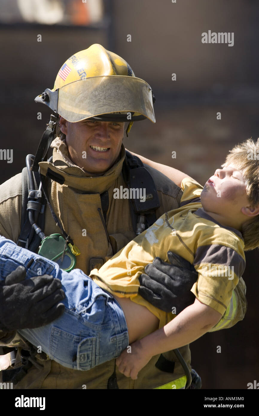 Firefighter carrying a wounded boy Stock Photo - Alamy