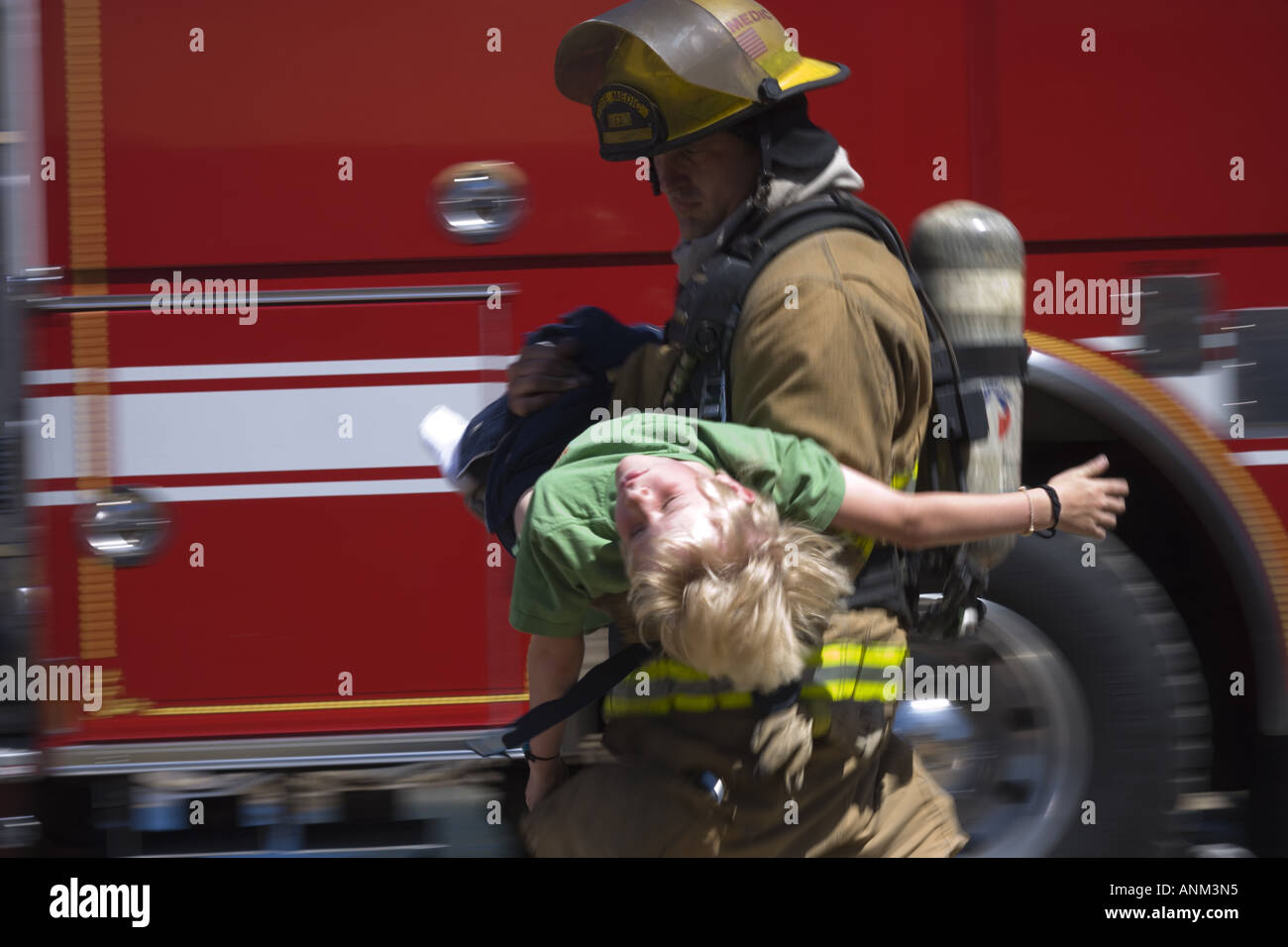Profile of a firefighter carrying a boy Stock Photo - Alamy
