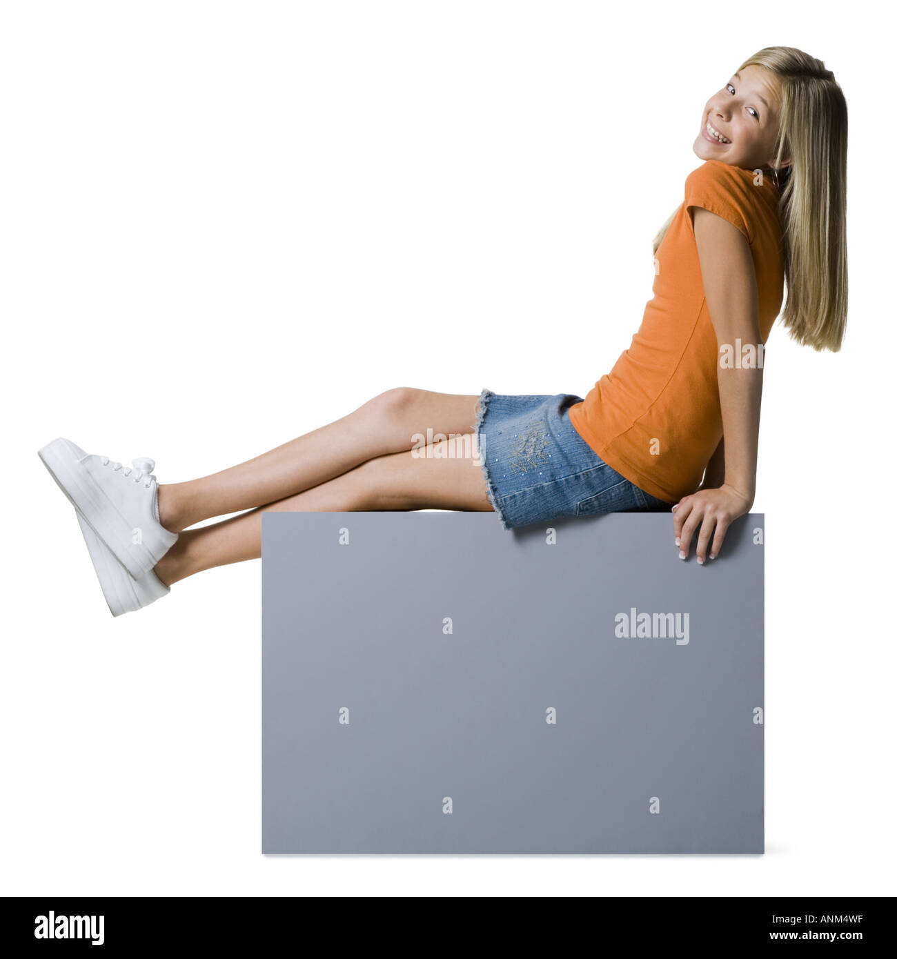 Portrait of a girl sitting on a blank sign Stock Photo - Alamy