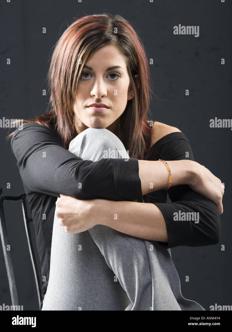 Sitting looking at camera contemplation hugging knees hi-res stock ...