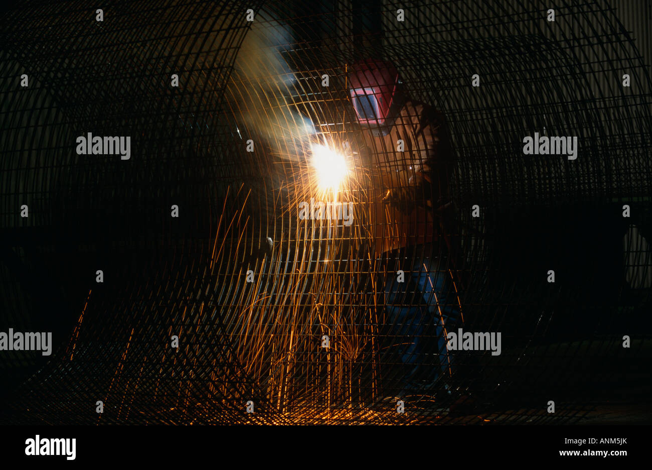 A welder joins wire cages with an oxy-acetylene torch for precast ...