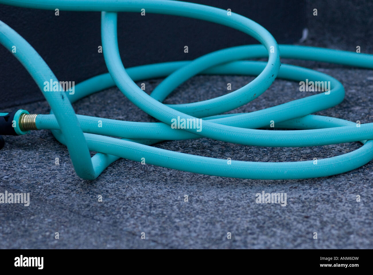 jumbled hose on concrete pavement Stock Photo - Alamy