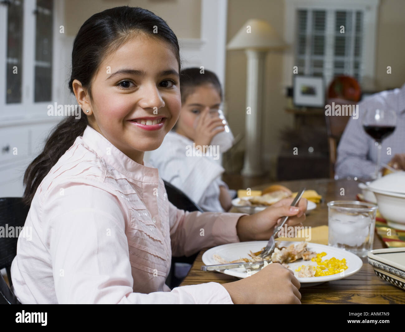 Portrait of a teenage girl sitting at a dining table and smiling Stock ...