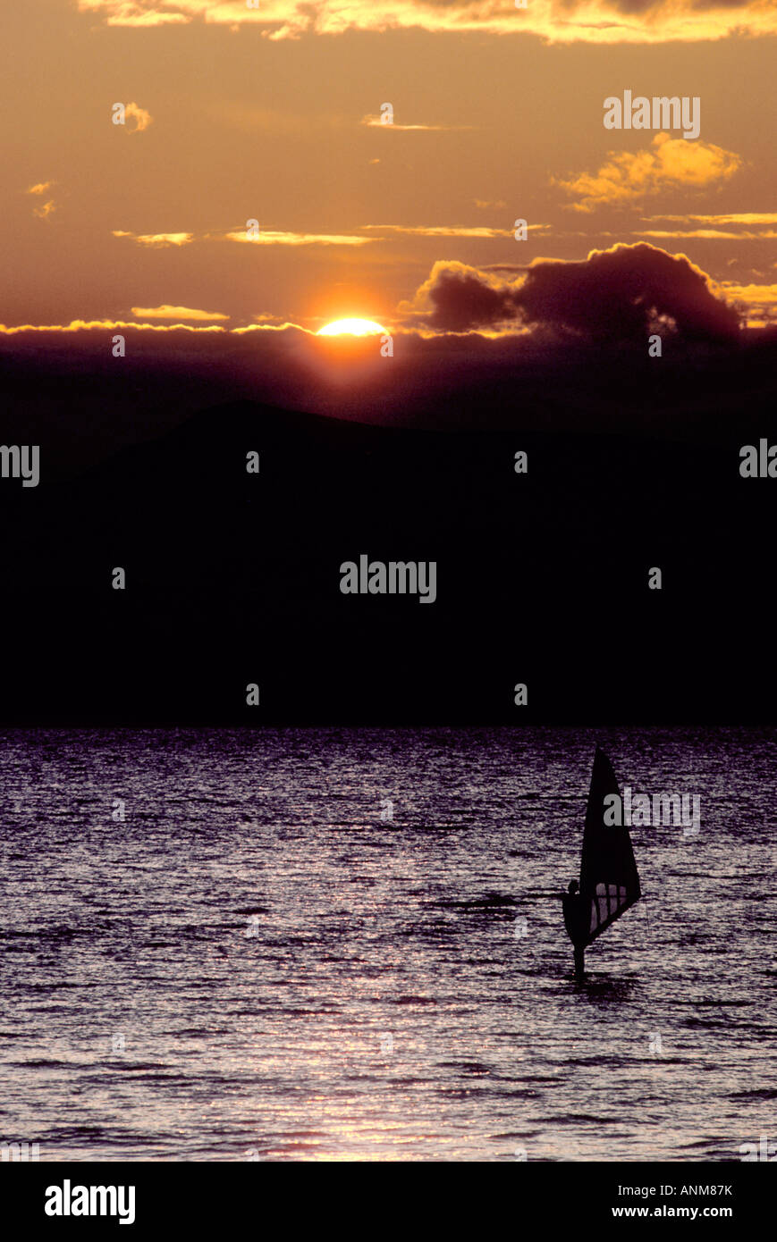 A sailboard sails along during sunset in Burlington, Vermont on Lake ...