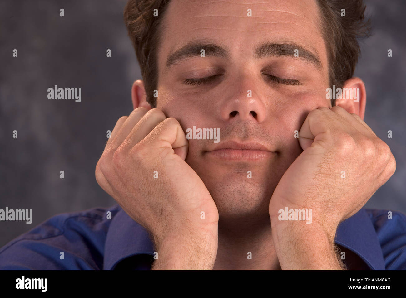 Man resting his chin in his hands with eyes closed Stock Photo - Alamy