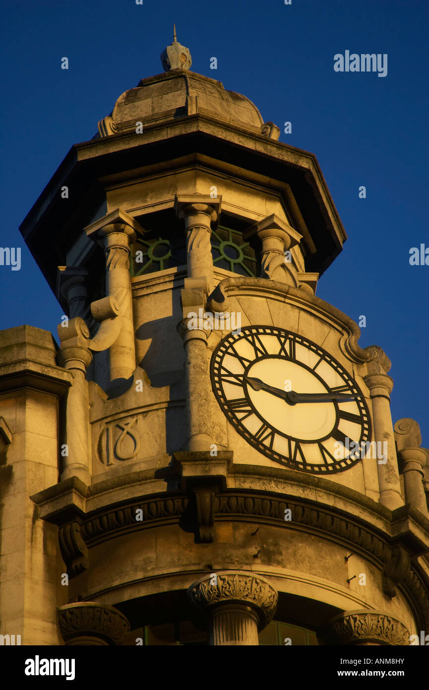 A stone clock tower with a blue sky backdrop Stock Photo - Alamy