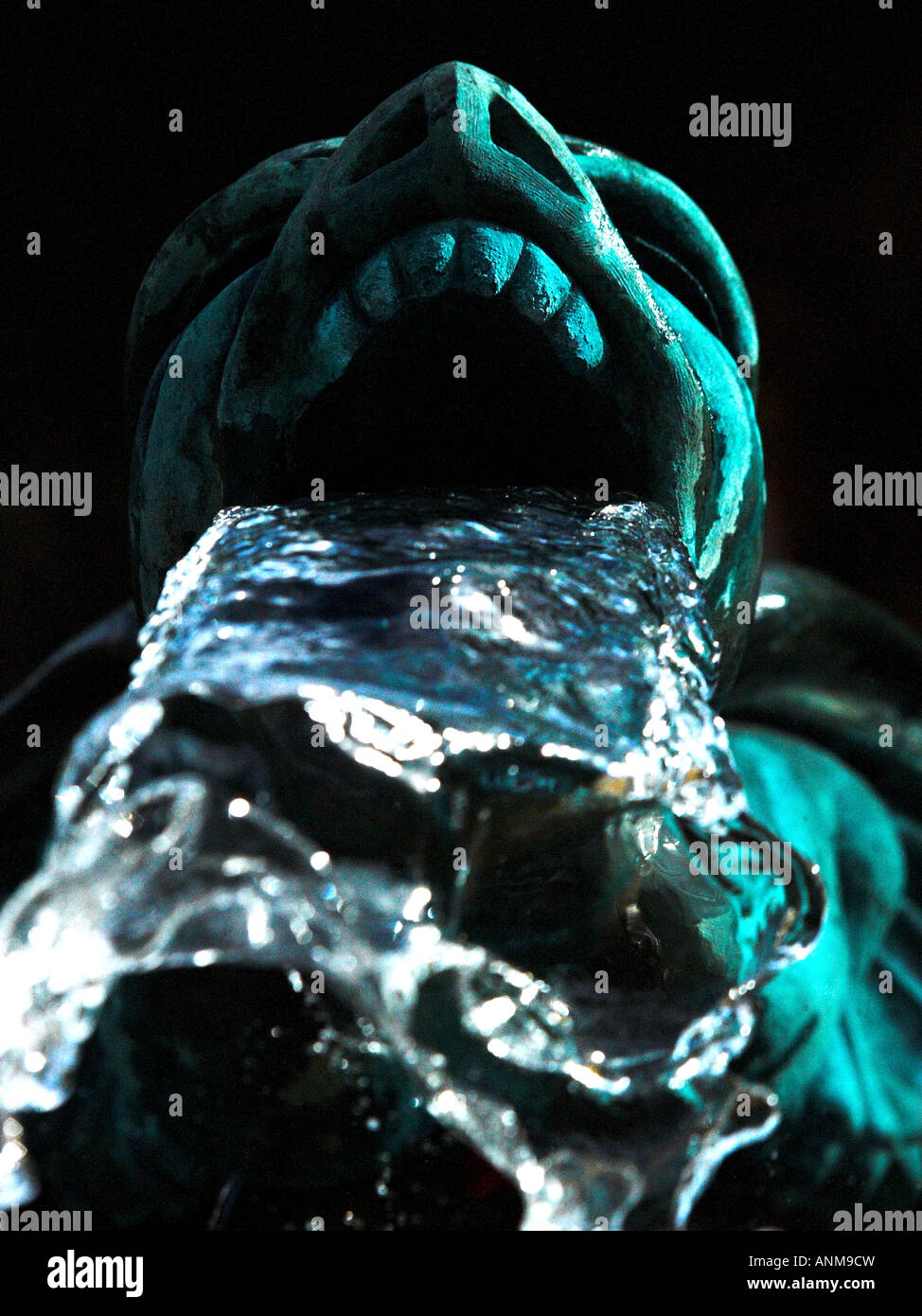 Statue of green gargoyle in fountain spouting water Stock Photo - Alamy