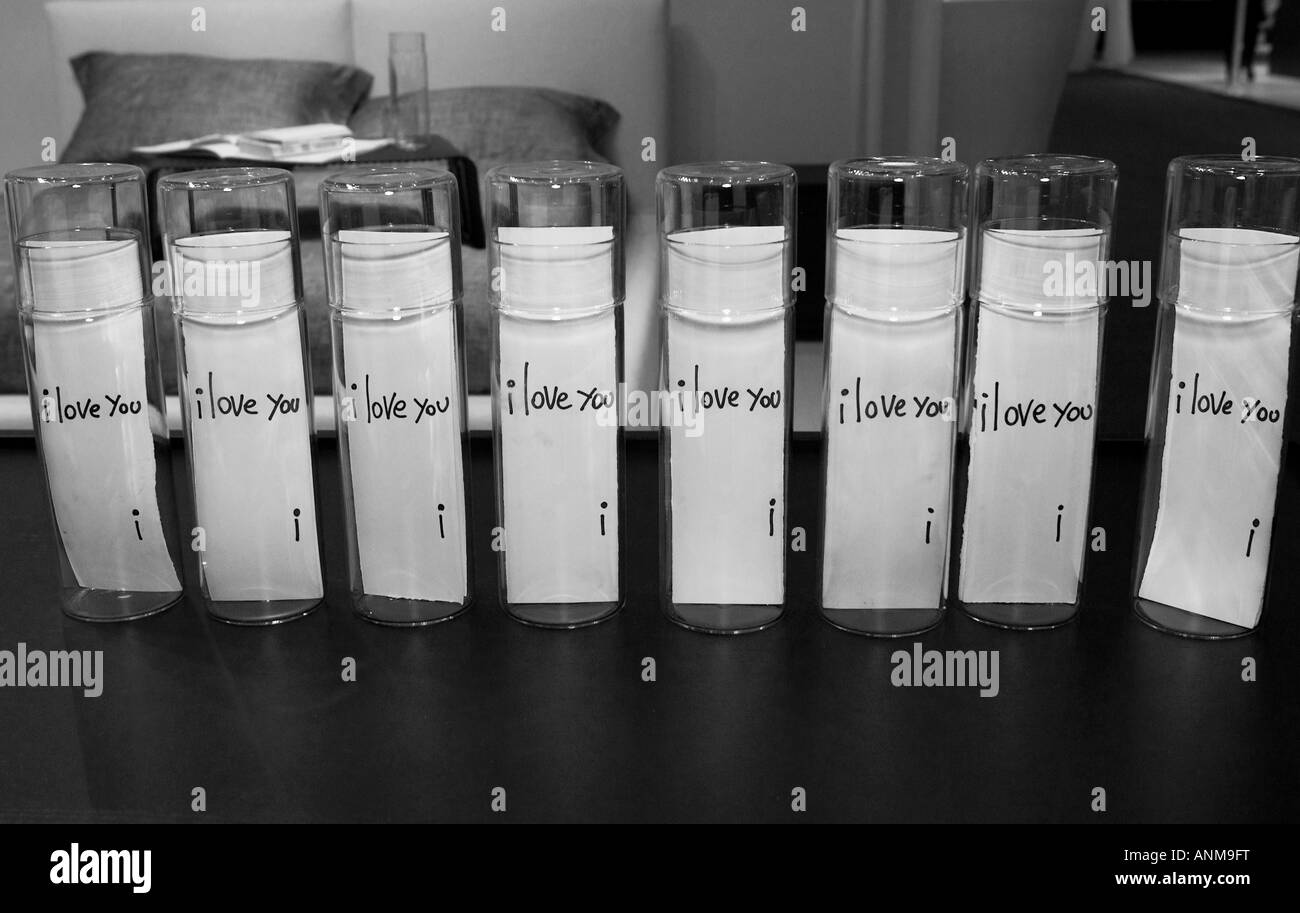 "I Love You" notes in clear glass tube lined containers sitting on ...