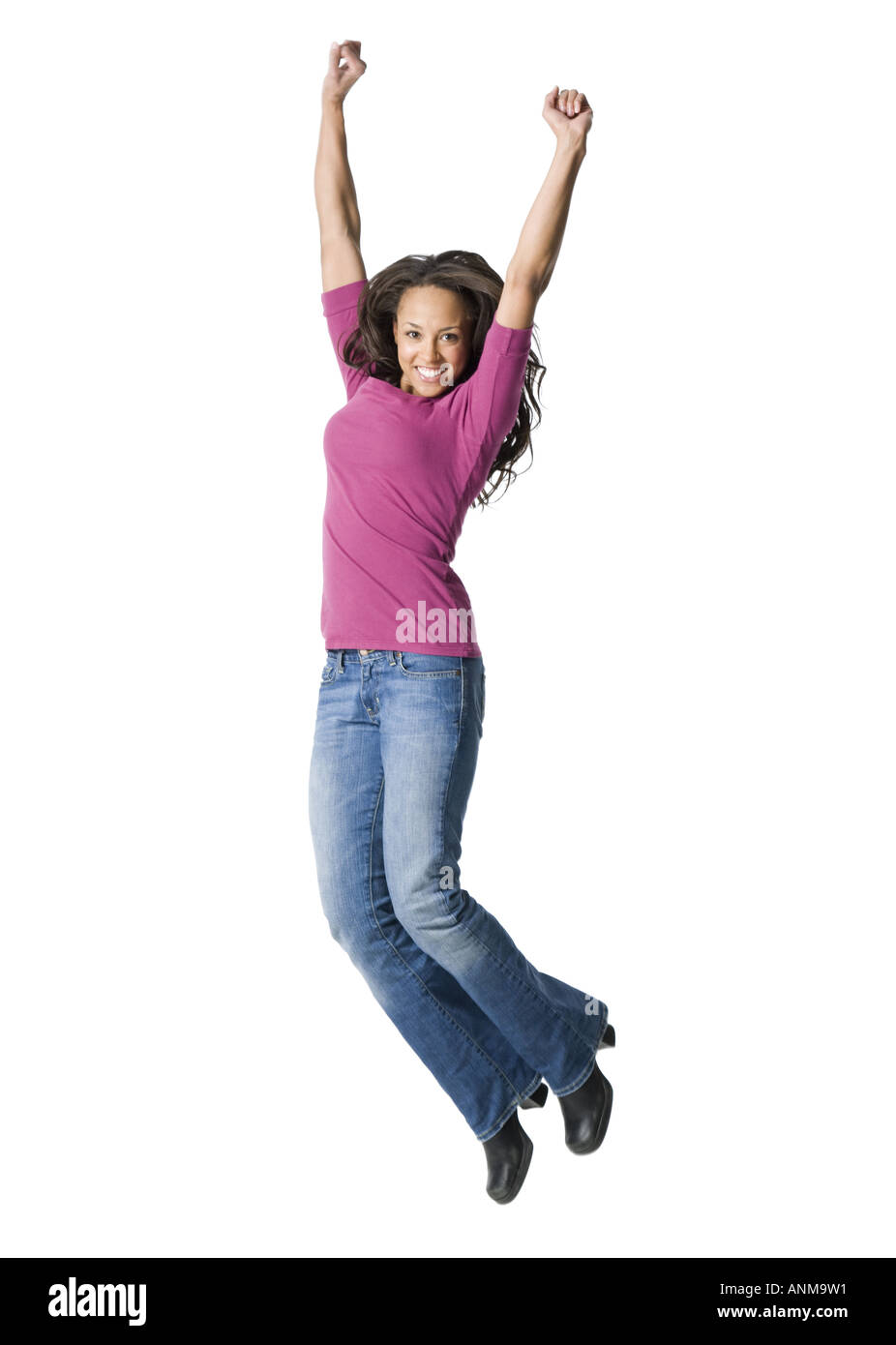 Portrait of a young woman jumping with her arms raised Stock Photo - Alamy