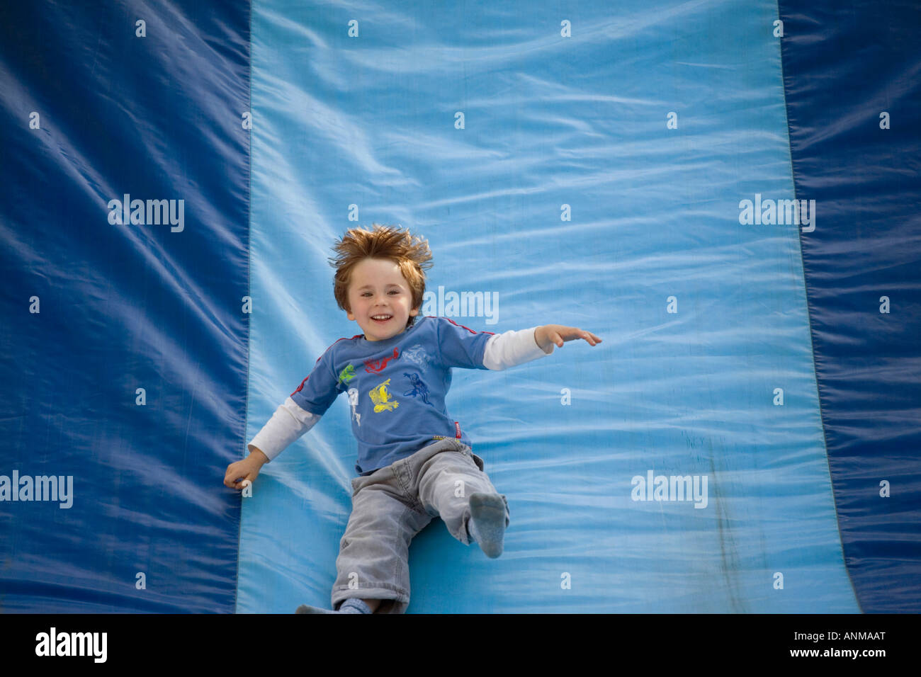 Boy sliding down inflatable slide Stock Photo - Alamy