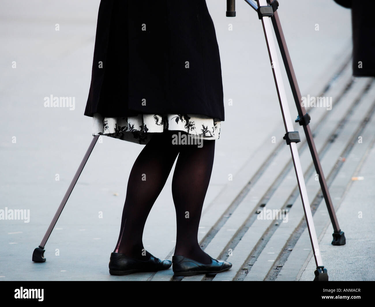 legs of woman using camera tripod Stock Photo - Alamy
