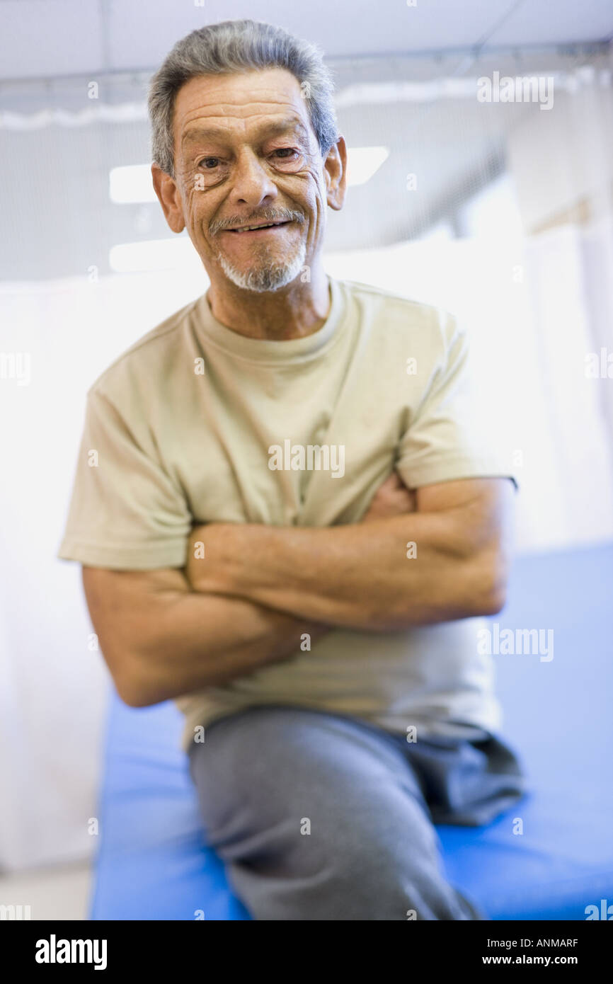 Portrait of a physically challenged senior man smiling with his arms ...