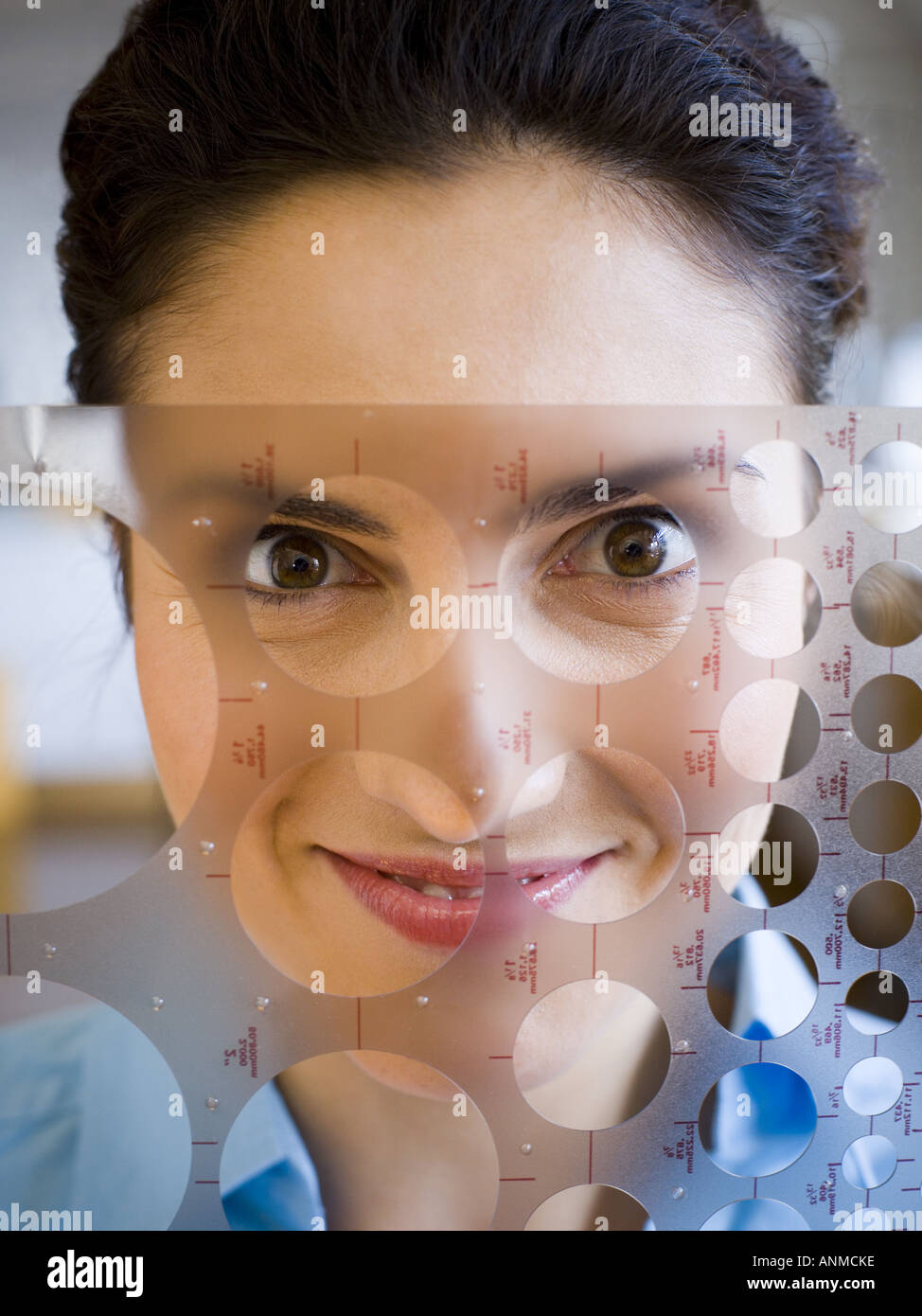 Portrait of a young woman looking through a stencil Stock Photo - Alamy