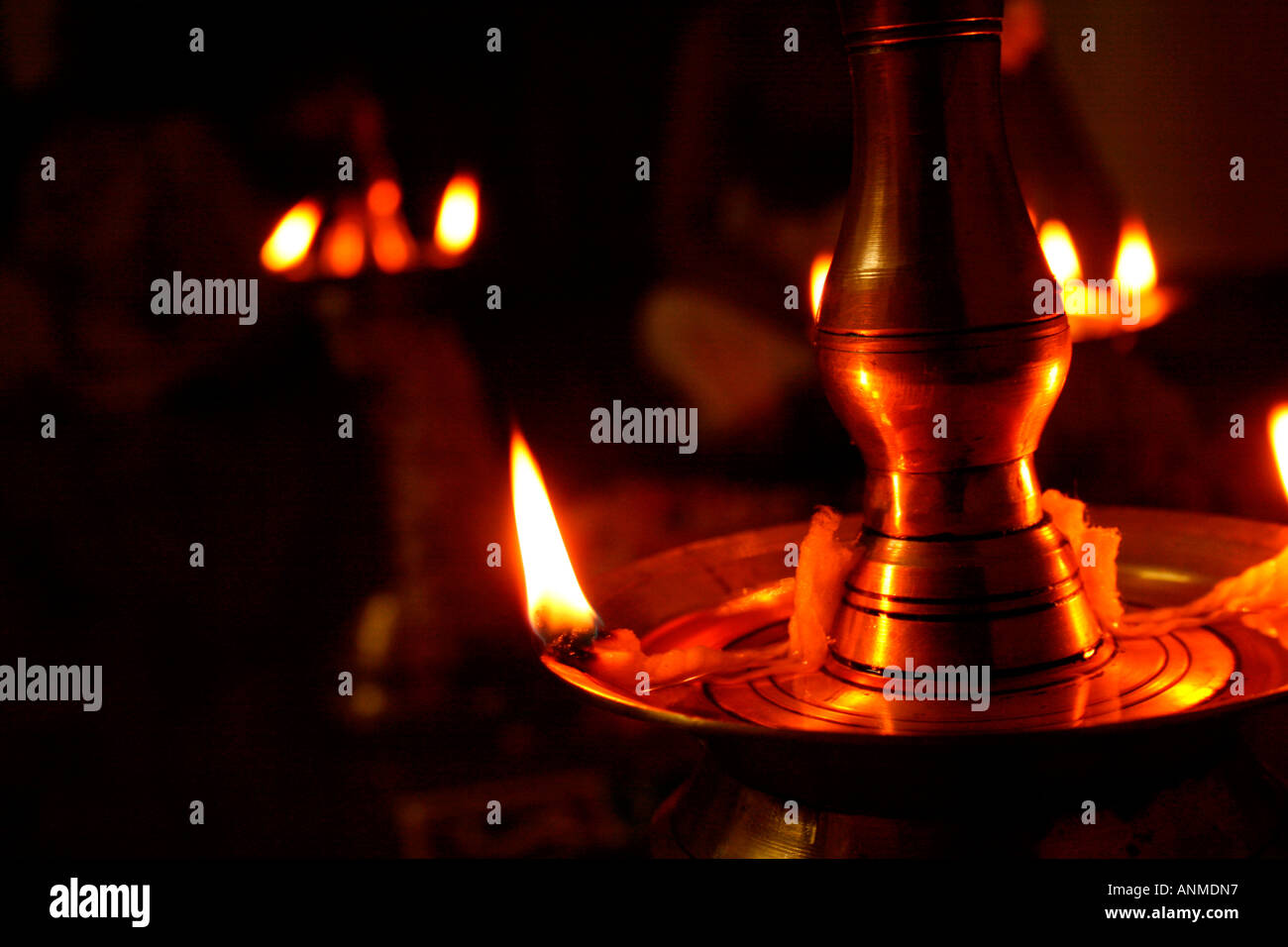 Close up of a burning wick in a traditional Kerala style brass lamp ...