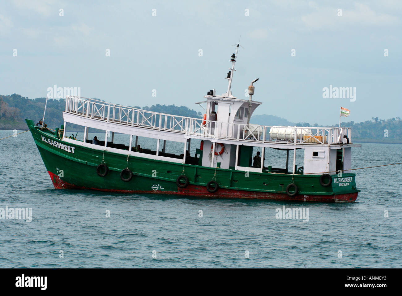 A boat in the blue waters at Jolly buoy Andaman with a view of the land ...